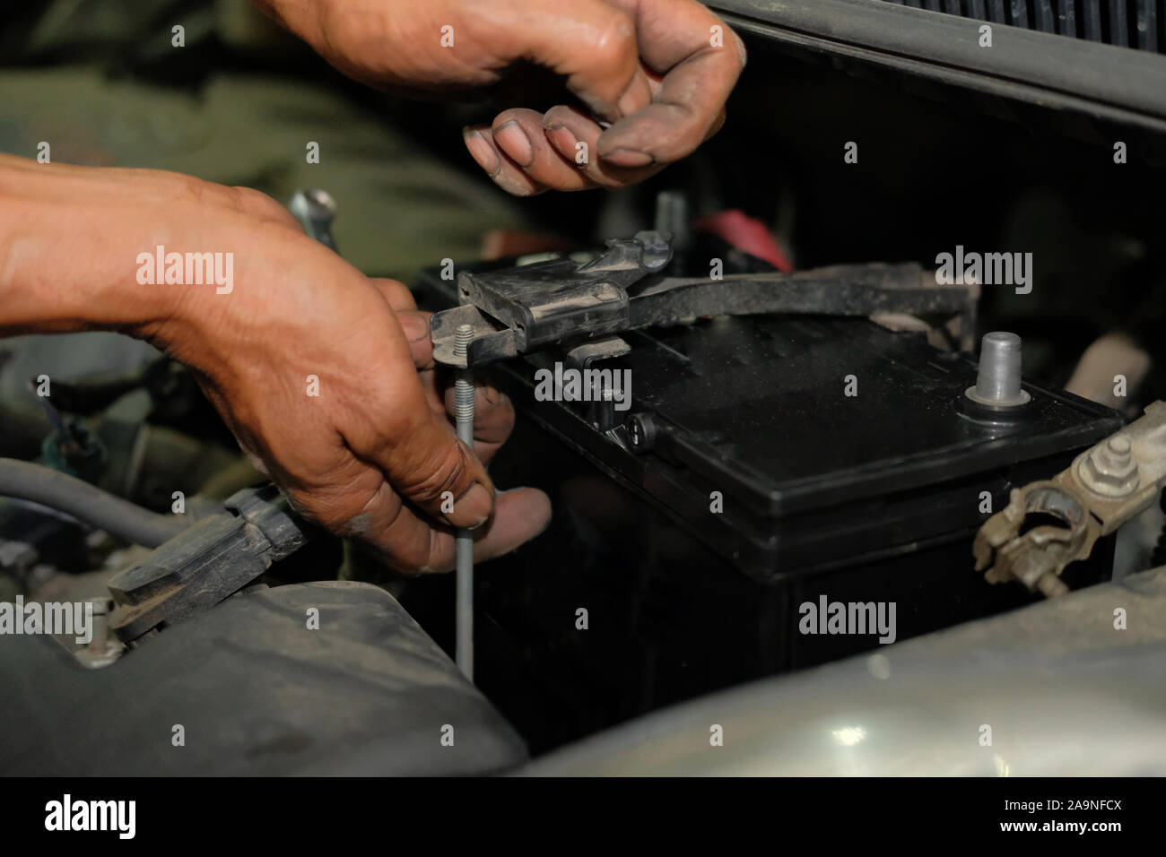 technician changing car battery in auto repair garage shop Stock Photo ...