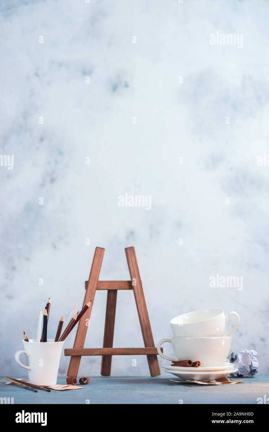 Artist workplace with coffee cups, pencils, swatches on a light ...