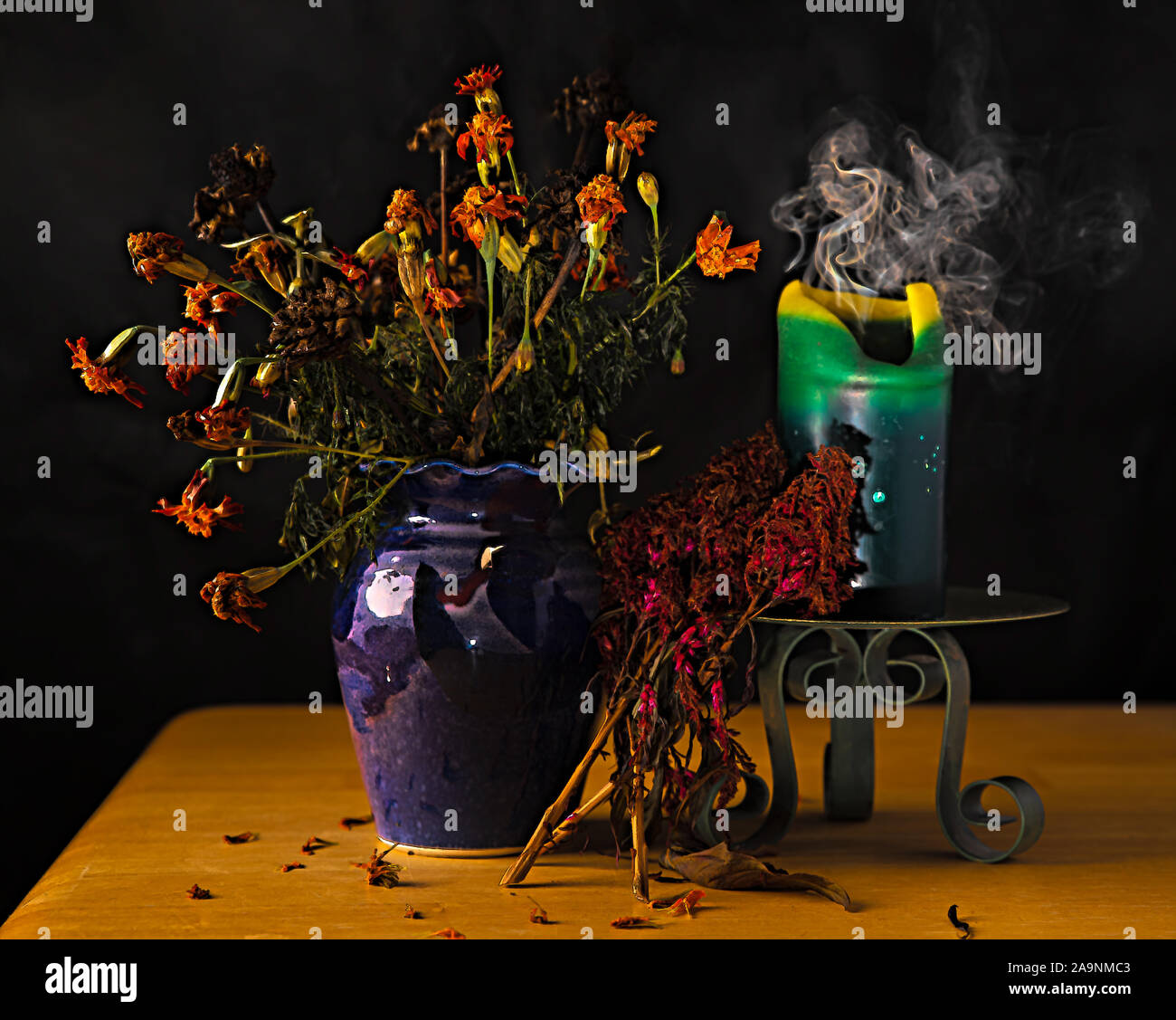 Still life with dead flowers, burnt out candle, and vase on table, all ...