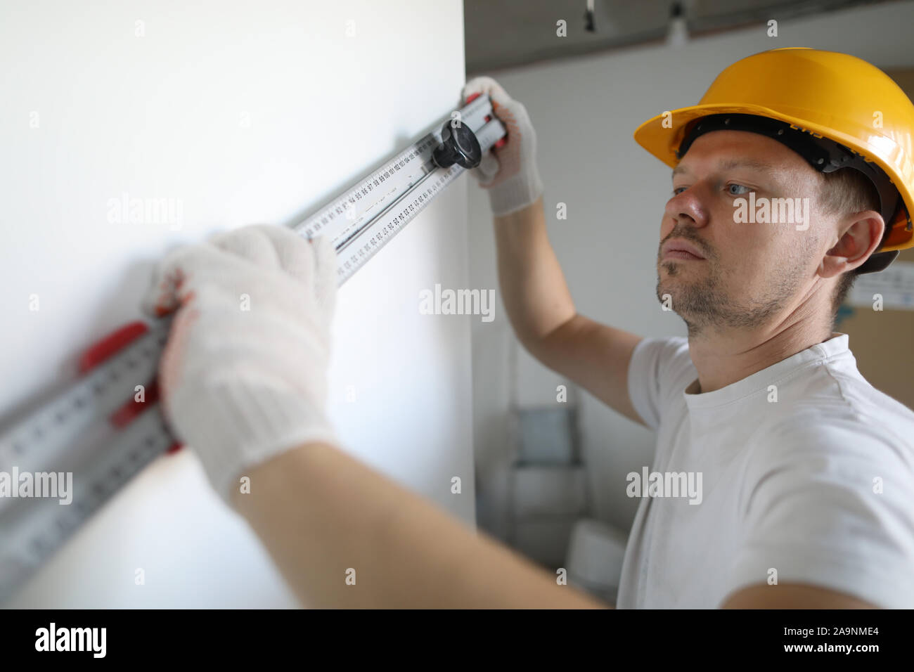 Worker making wall straight Stock Photo - Alamy