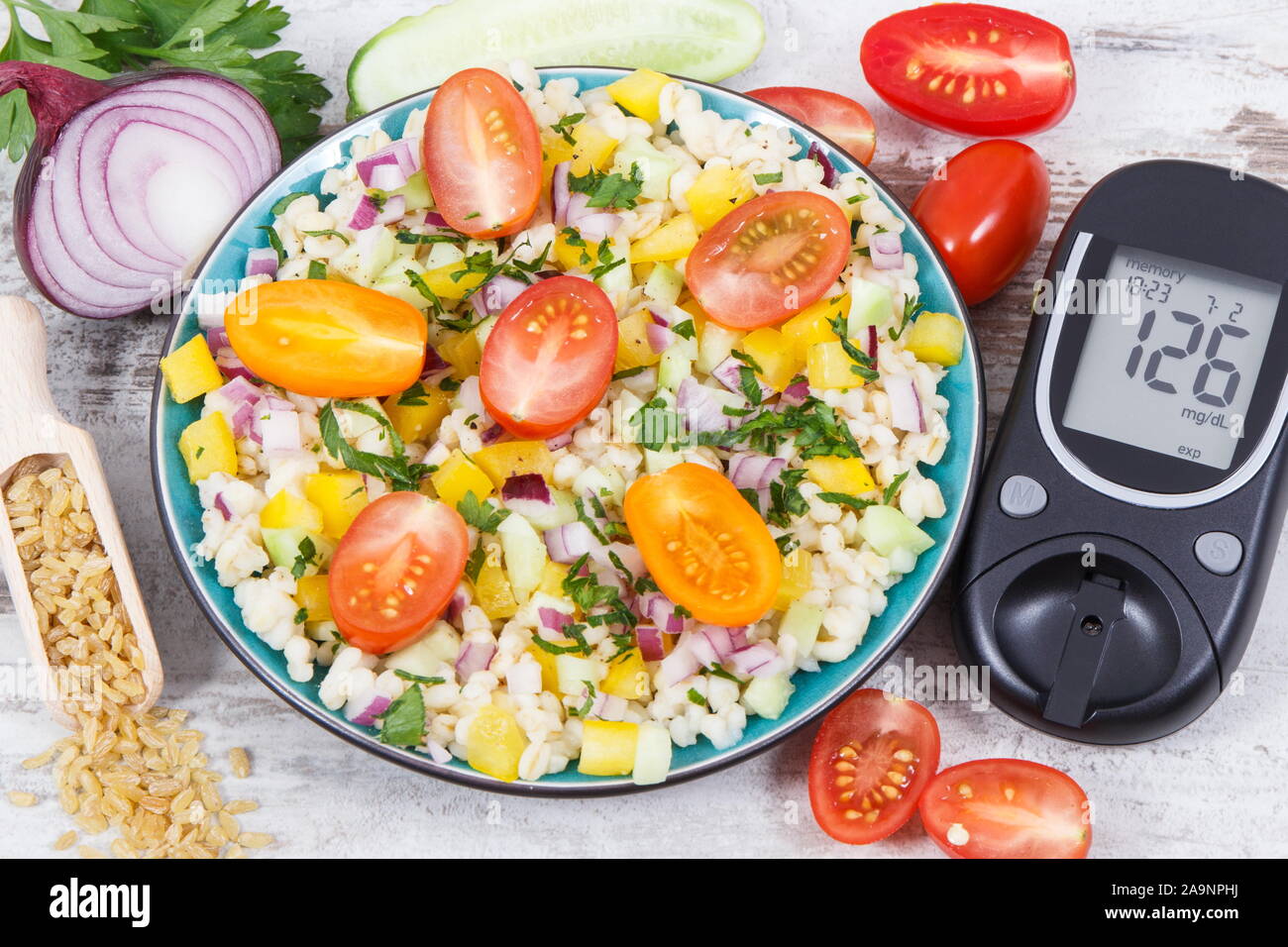 Glucose meter with result of sugar level, salad with vegetables and ...