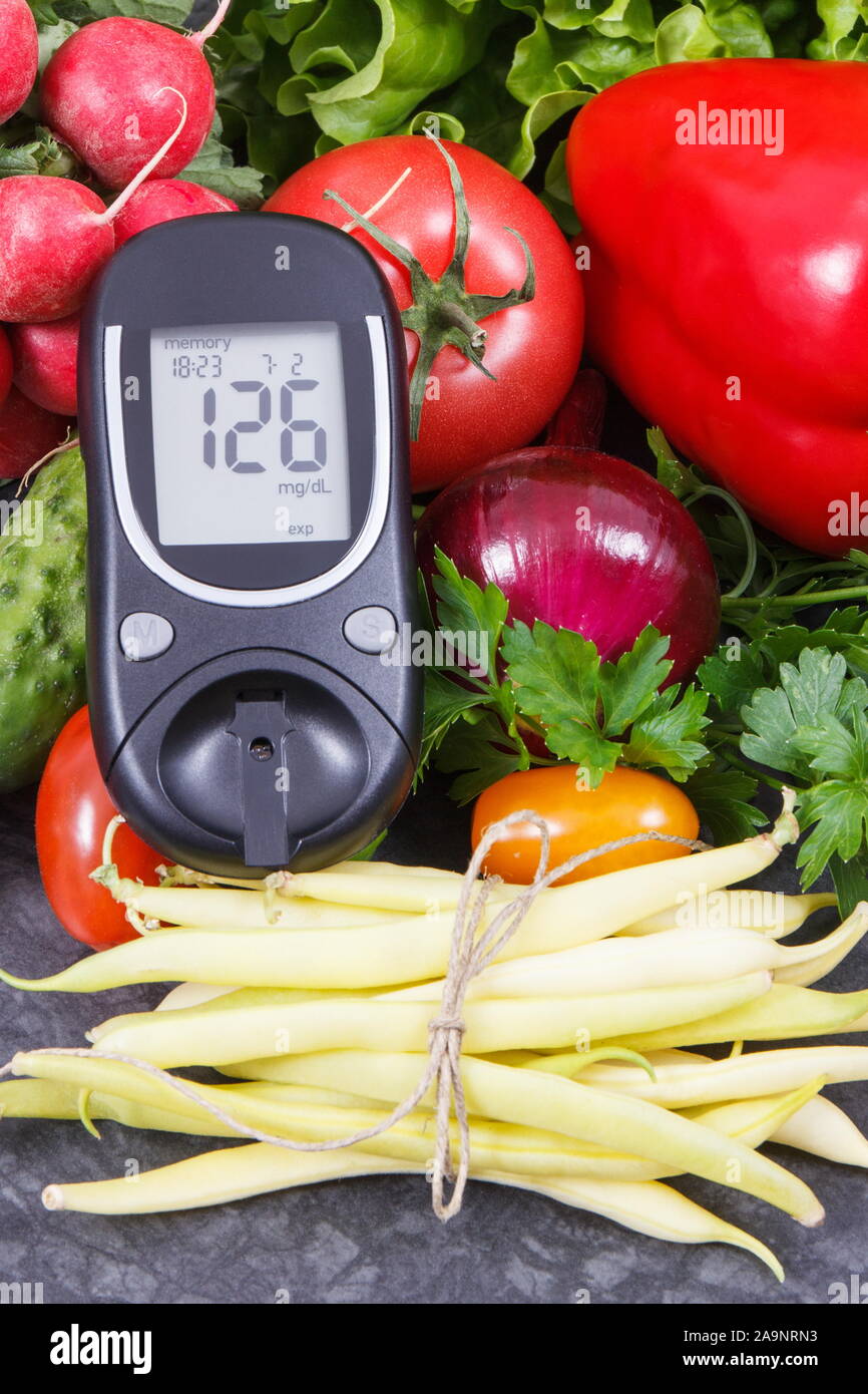 Glucometer with result of sugar level and fresh ripe vegetables as food ...