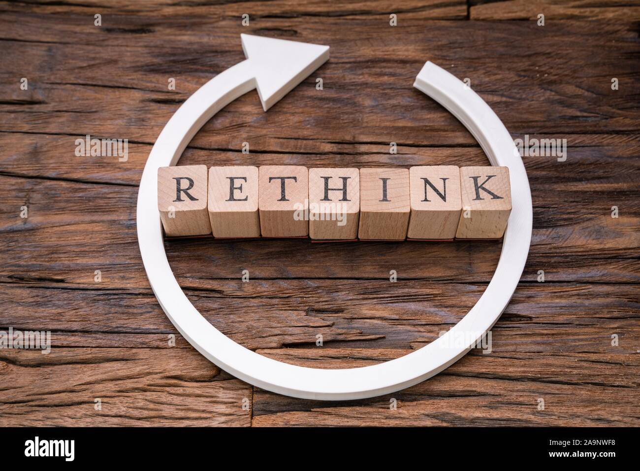 Rethink Word On Wooden Blocks Near White Directional Arrow Over ...