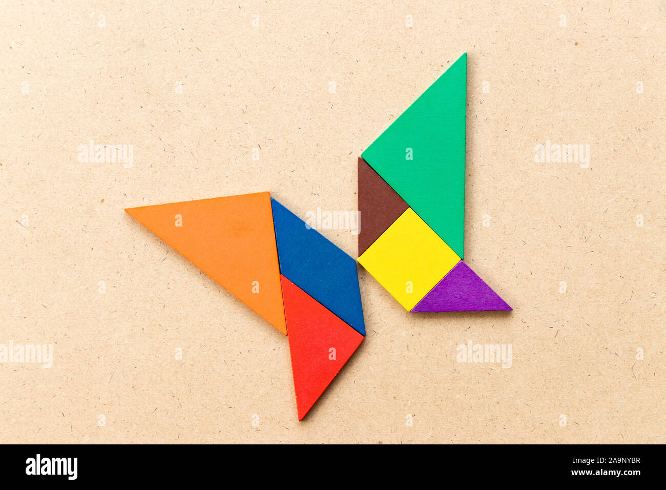 Color tangram puzzle in butterfly shape on wood background Stock Photo ...