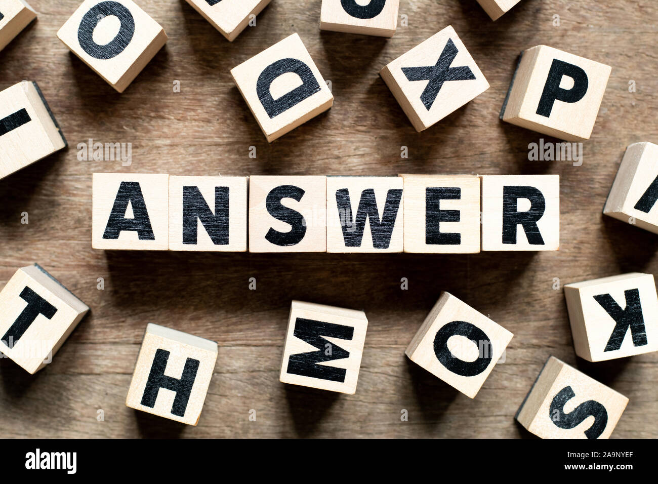 Letter block with word answer on wood background with another alphabet ...
