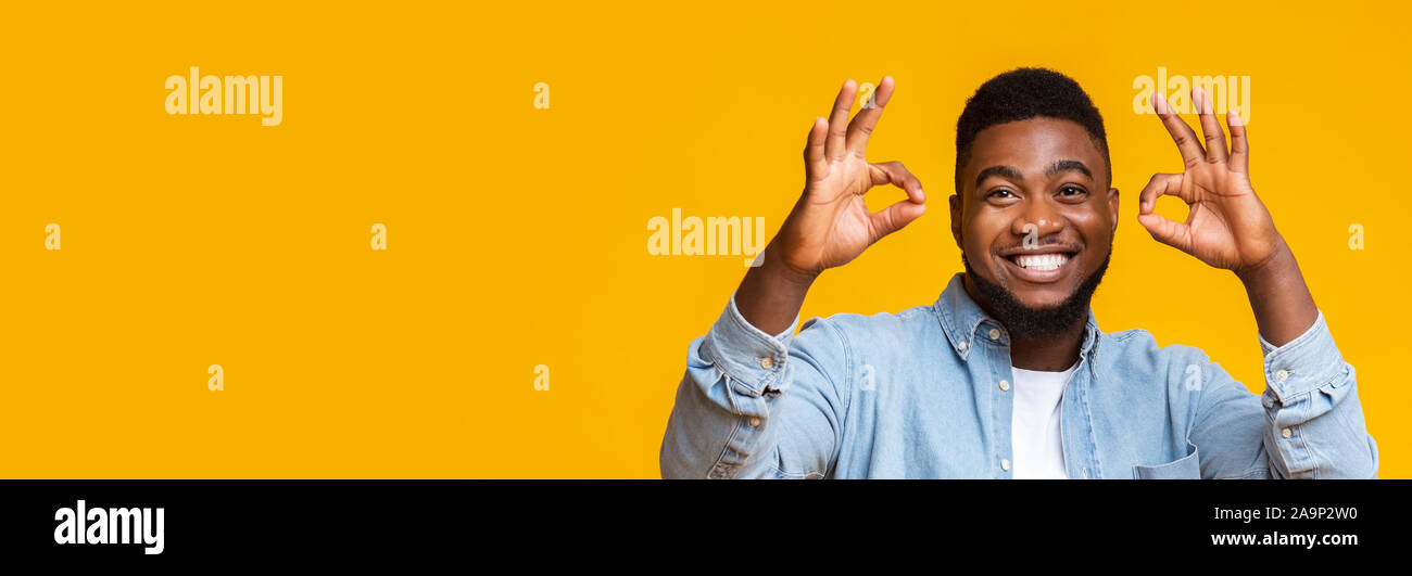 Positive black man gesturing ok sign with both hands Stock Photo - Alamy