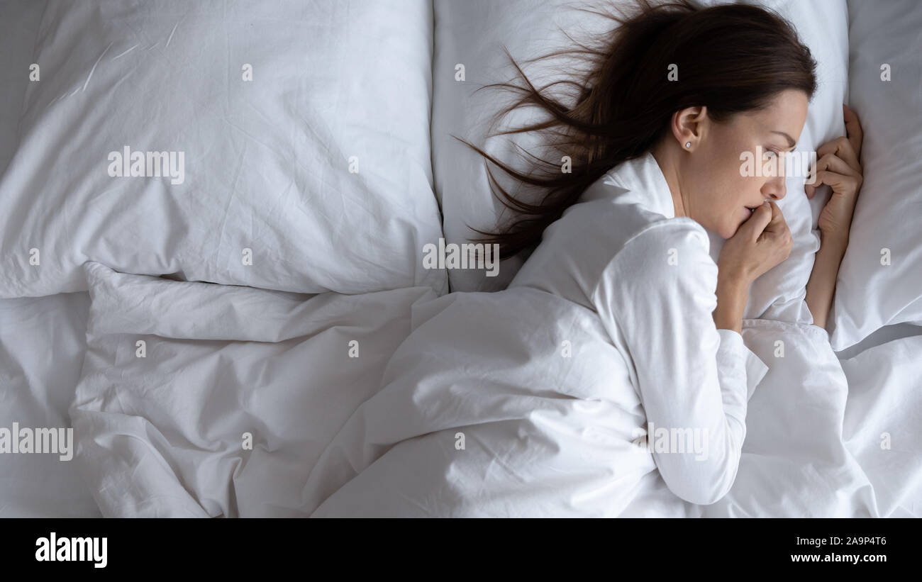 Awoken lonely scared woman lying in bed alone, top view Stock Photo - Alamy