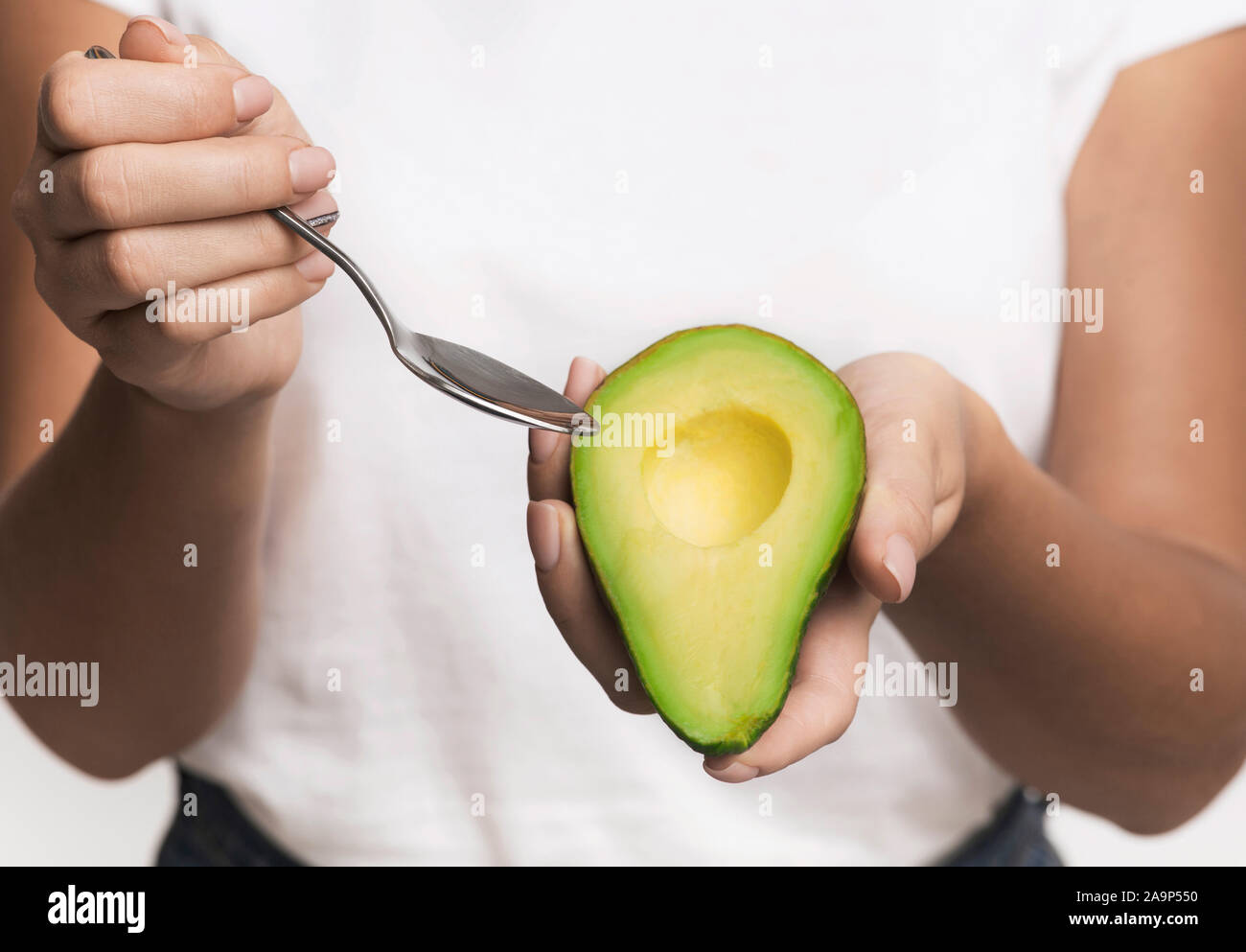 Woman Eating Avocado With Spoon Standing On White Background, Cropped ...