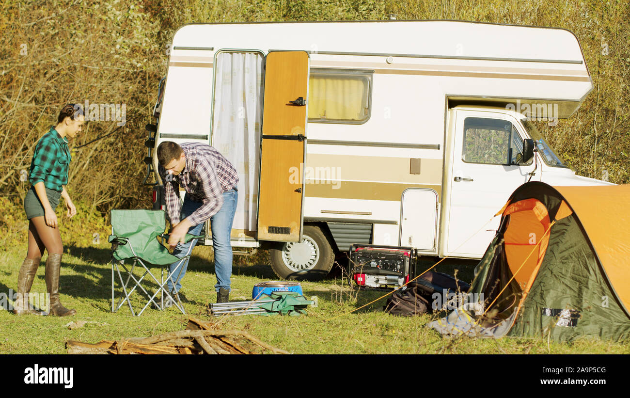 Beautiful young couple getting out of their retro camper van in the ...