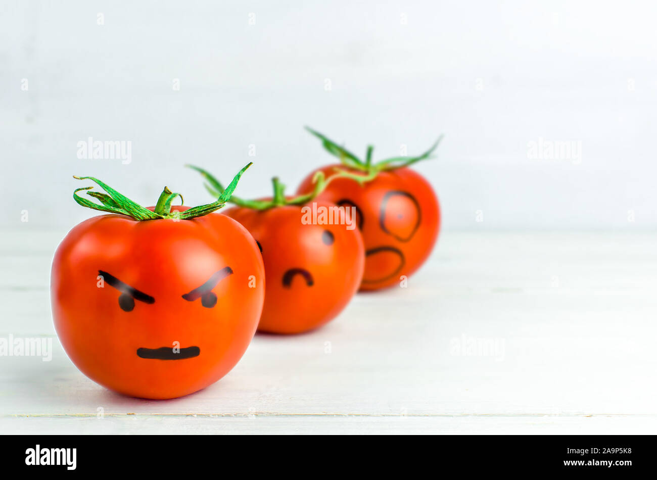 negative emotions on tomatoes. copy space. Angry, sad fear. White ...