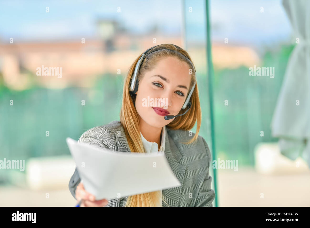 Young woman giving papers in workplace Stock Photo - Alamy
