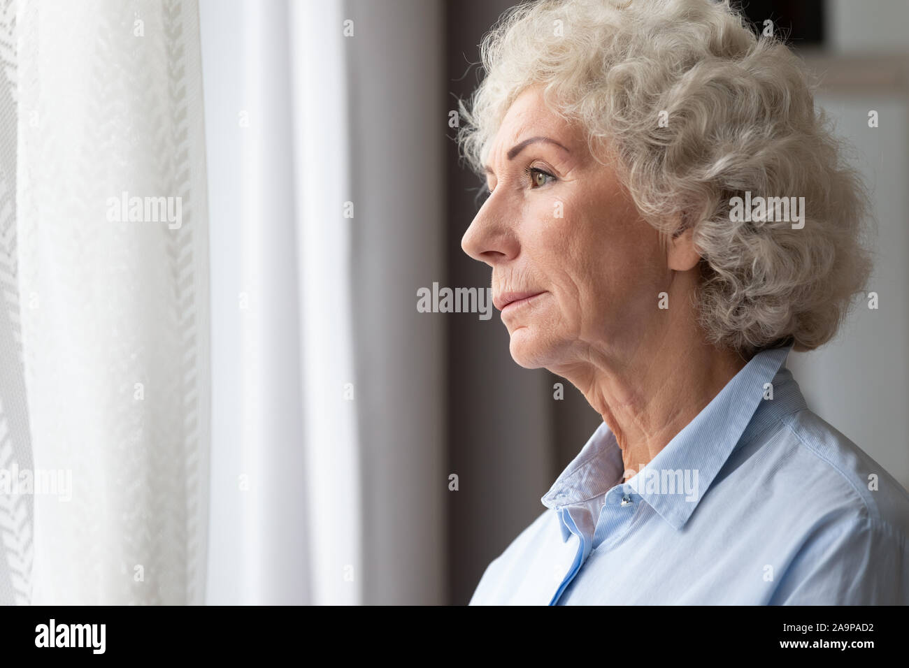 Pensive thoughtful lonely senior grandma looking through window Stock ...