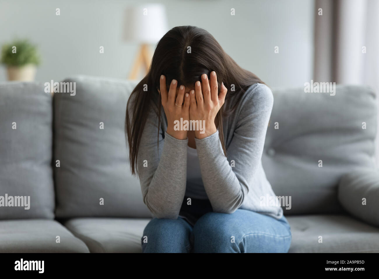 Sad depressed young woman crying alone at home Stock Photo - Alamy