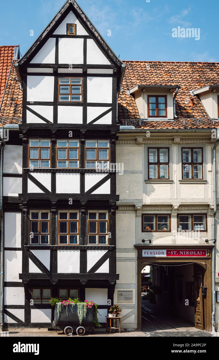 View of a framework white house and in front of it an old mining cart ...