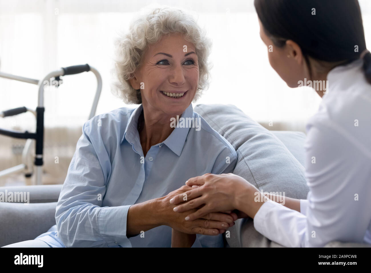 Caring nurse helping holding hands of happy disabled old woman Stock ...