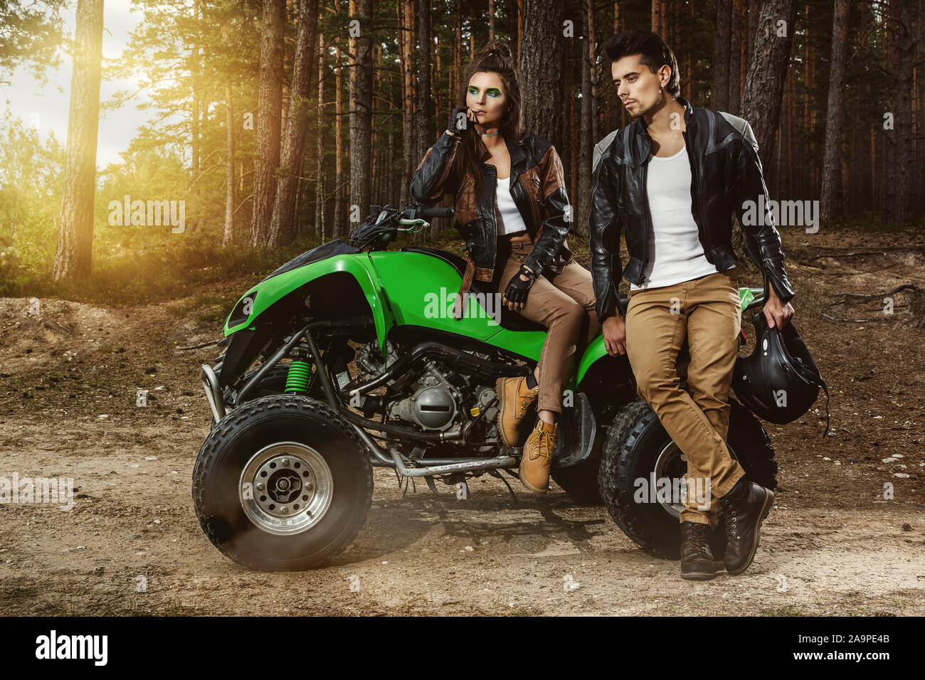 Stylish couple and ATV in the forest Stock Photo - Alamy