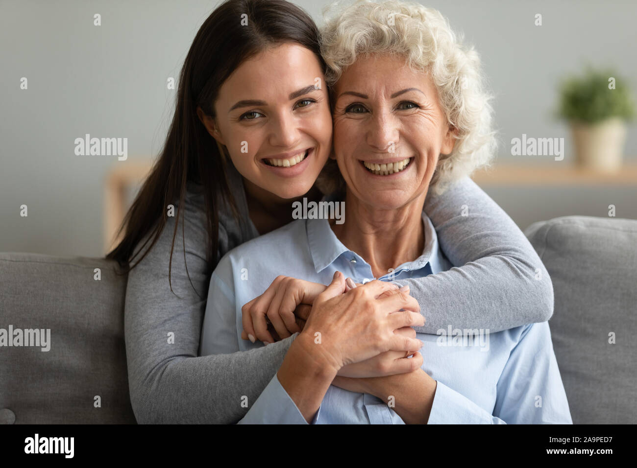 Happy two generation women hugging looking at camera, family portrait ...