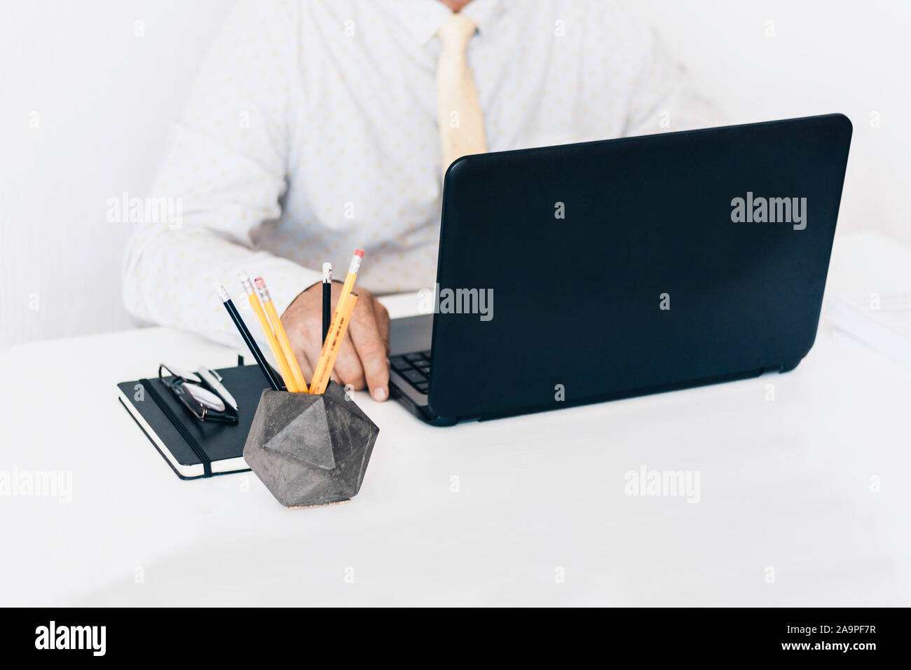 Close-up of hands middle-aged man in white shirt typing on keyboard ...