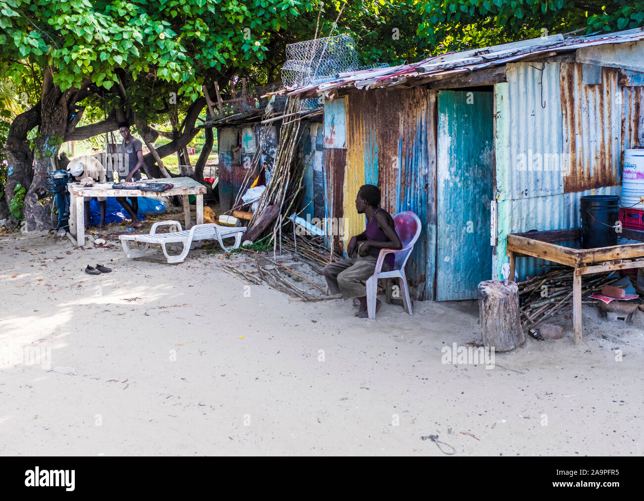 A fisherman relaxing by his huts on Fisherman's Beach, Runaway Bay ...