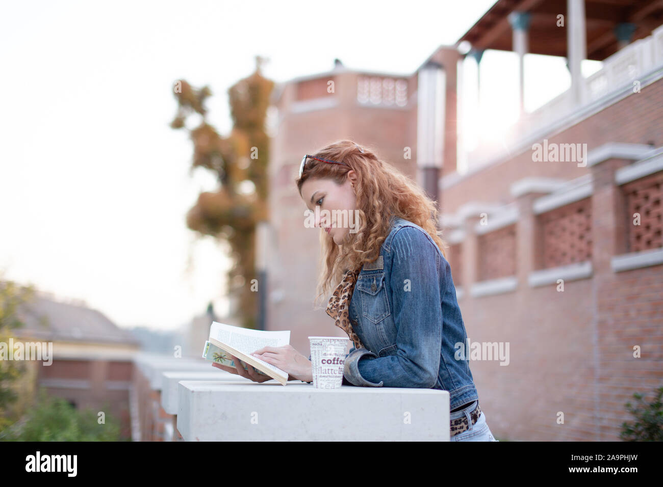 Young urban woman focus reading book outoors Stock Photo - Alamy