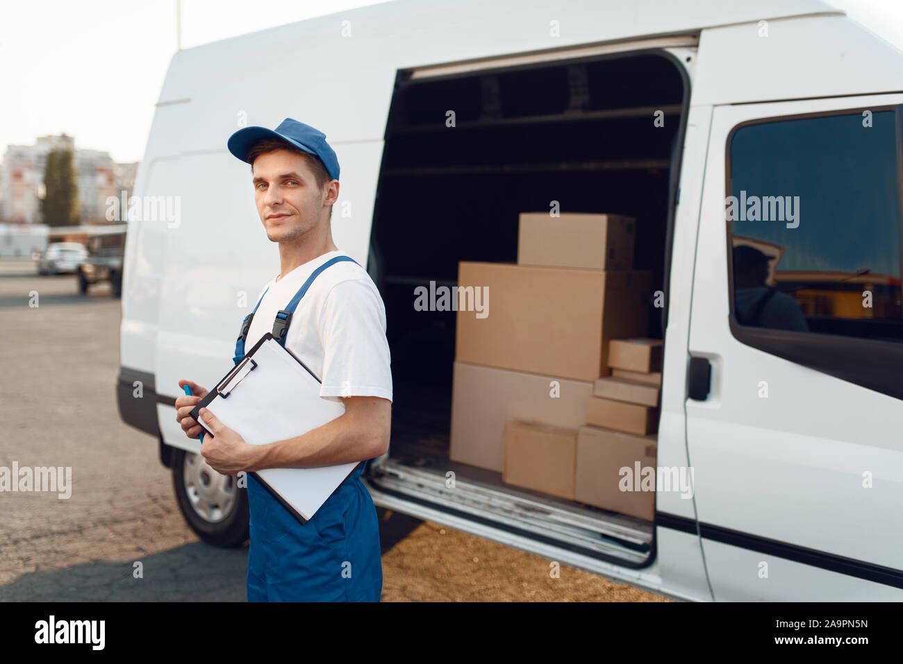 Deliveryman in uniform holding parcel, delivery Stock Photo - Alamy