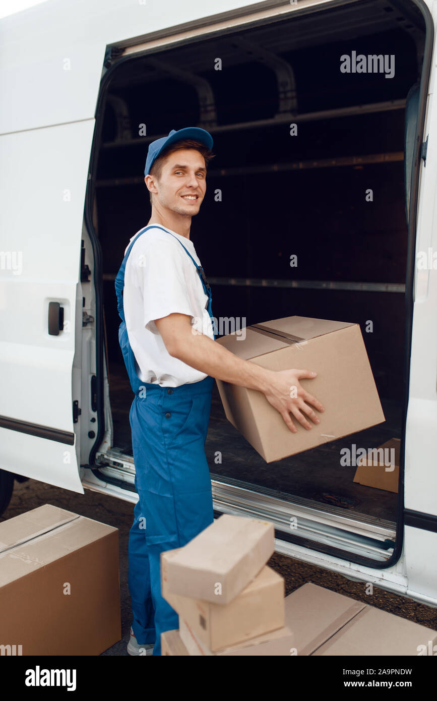 Deliveryman unloads the car with parcels, delivery Stock Photo - Alamy