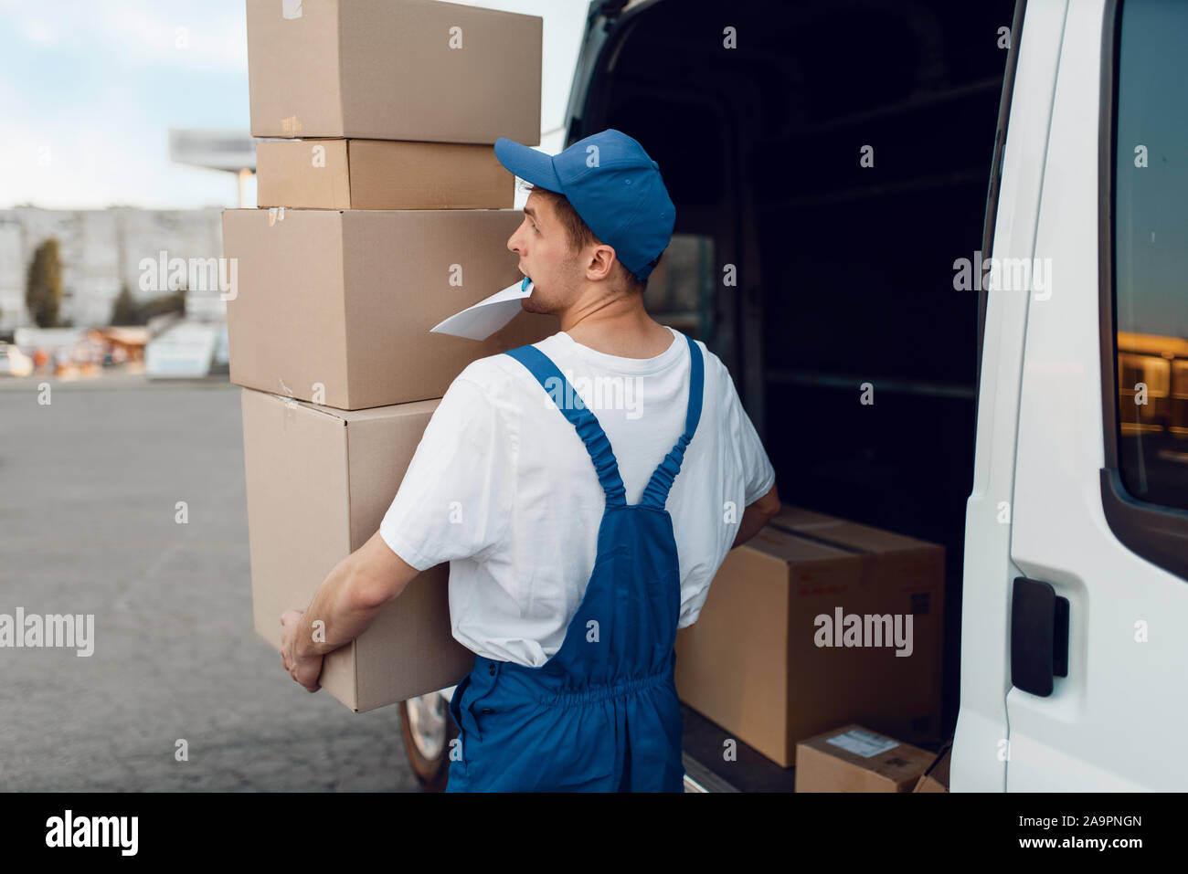 Mailman unloads the car with parcels, delivery Stock Photo - Alamy
