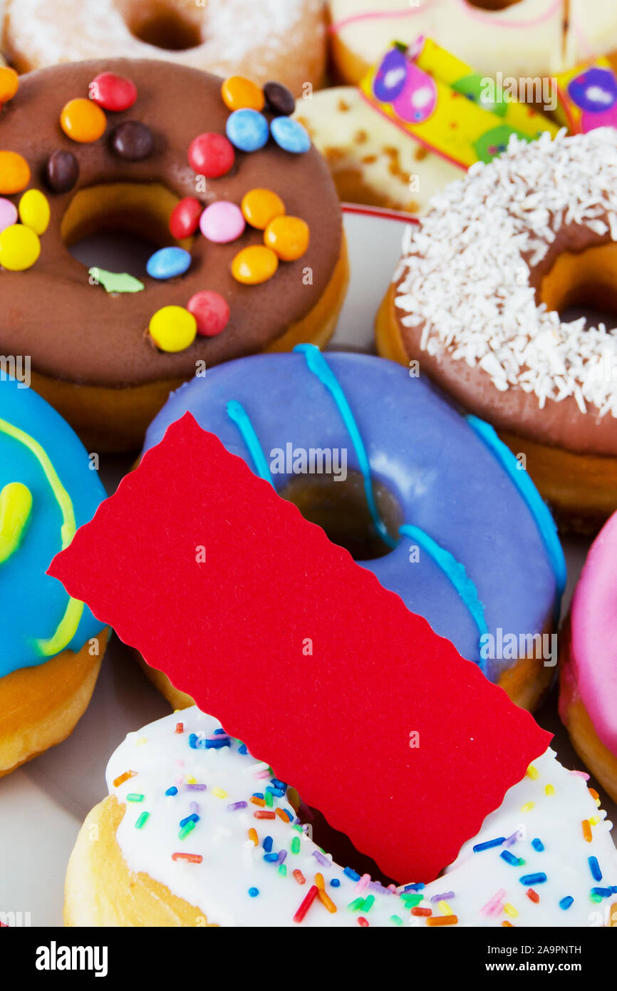 Colorful donuts with red label background Stock Photo - Alamy