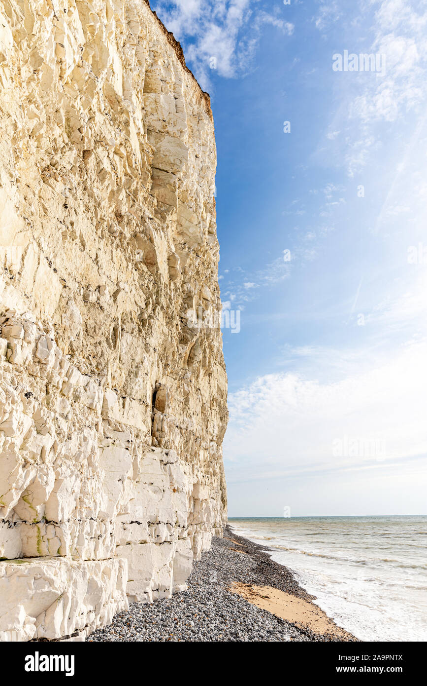 A close-up of the famous chalk cliffs at Beachy Head. Waves lap onto ...