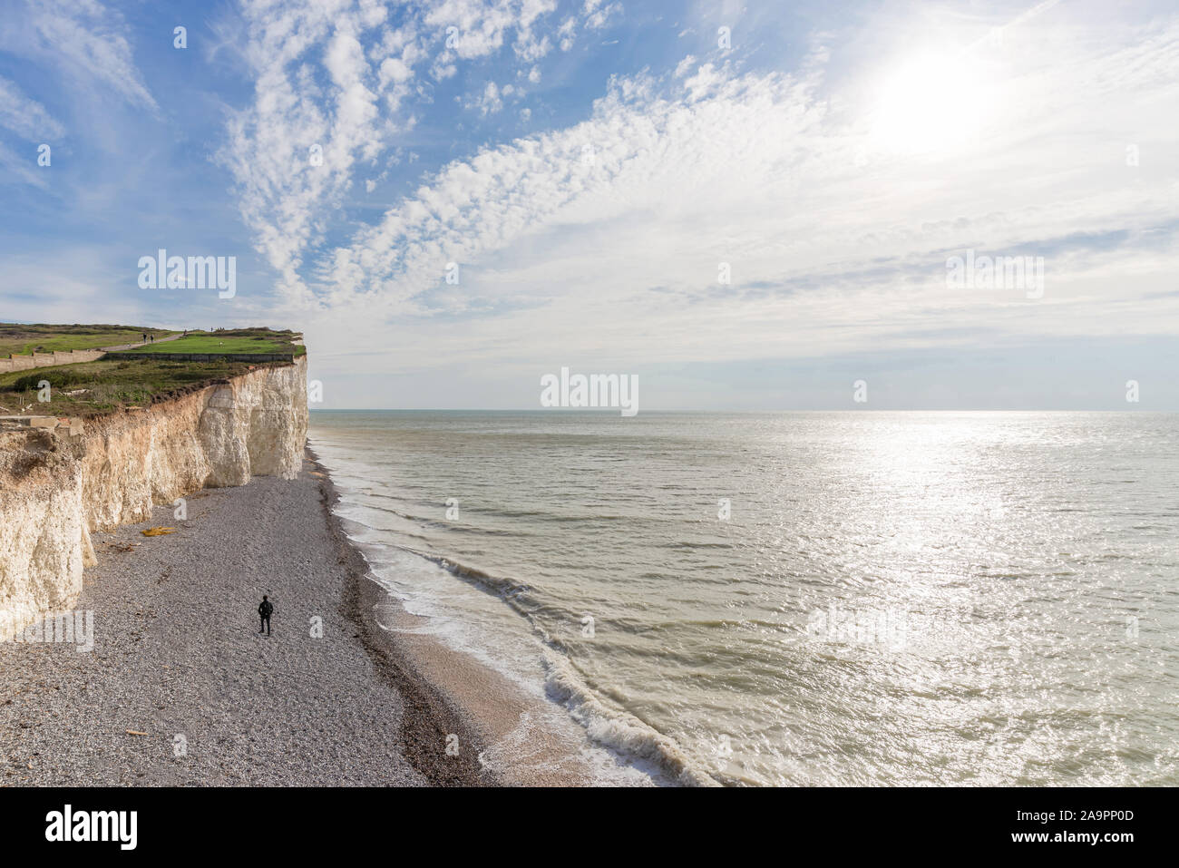 The famous chalk cliffs at Beachy Head. Waves lap onto the beach below ...