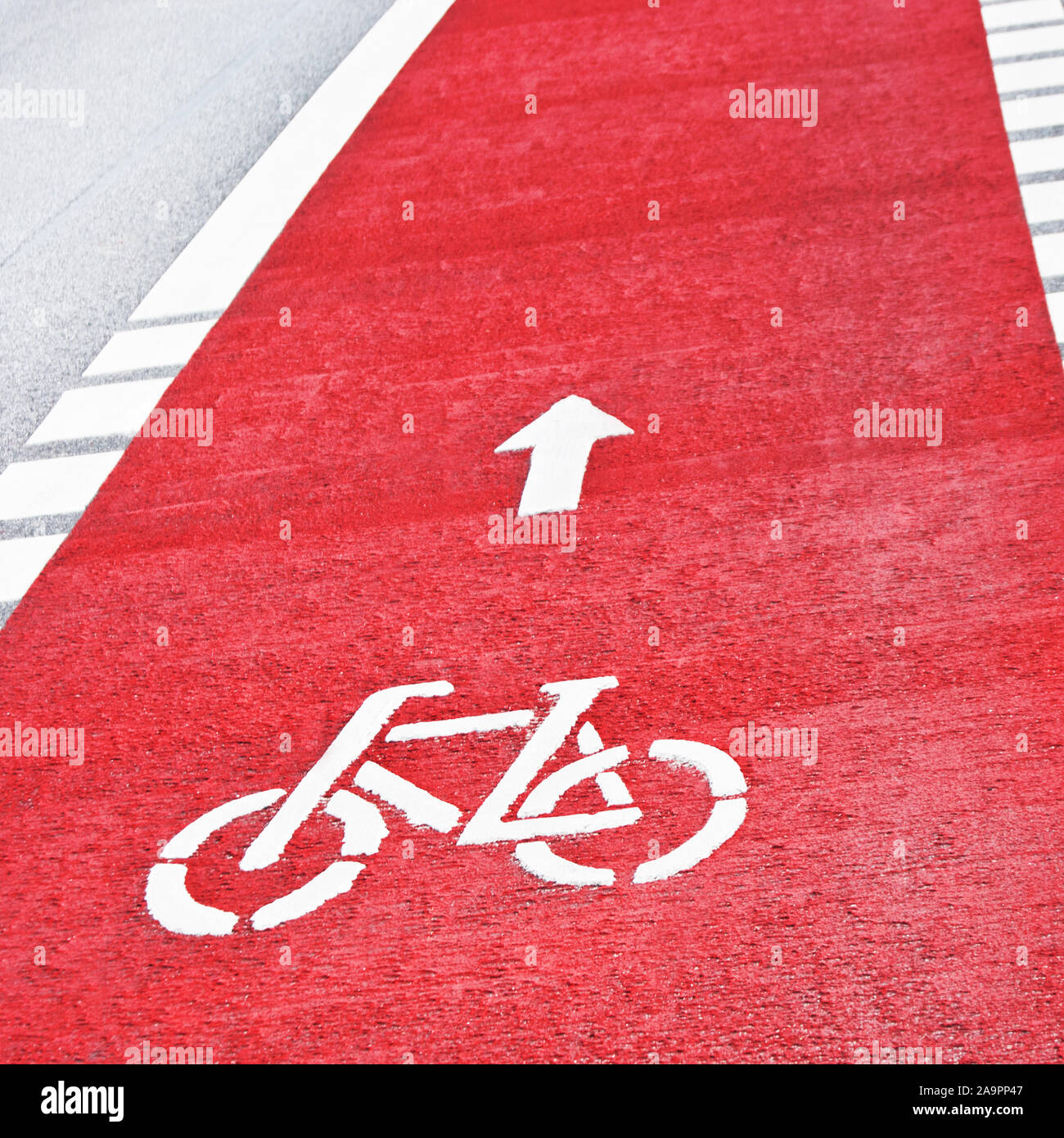 Red cycle path with direction arrow background close-up Stock Photo - Alamy