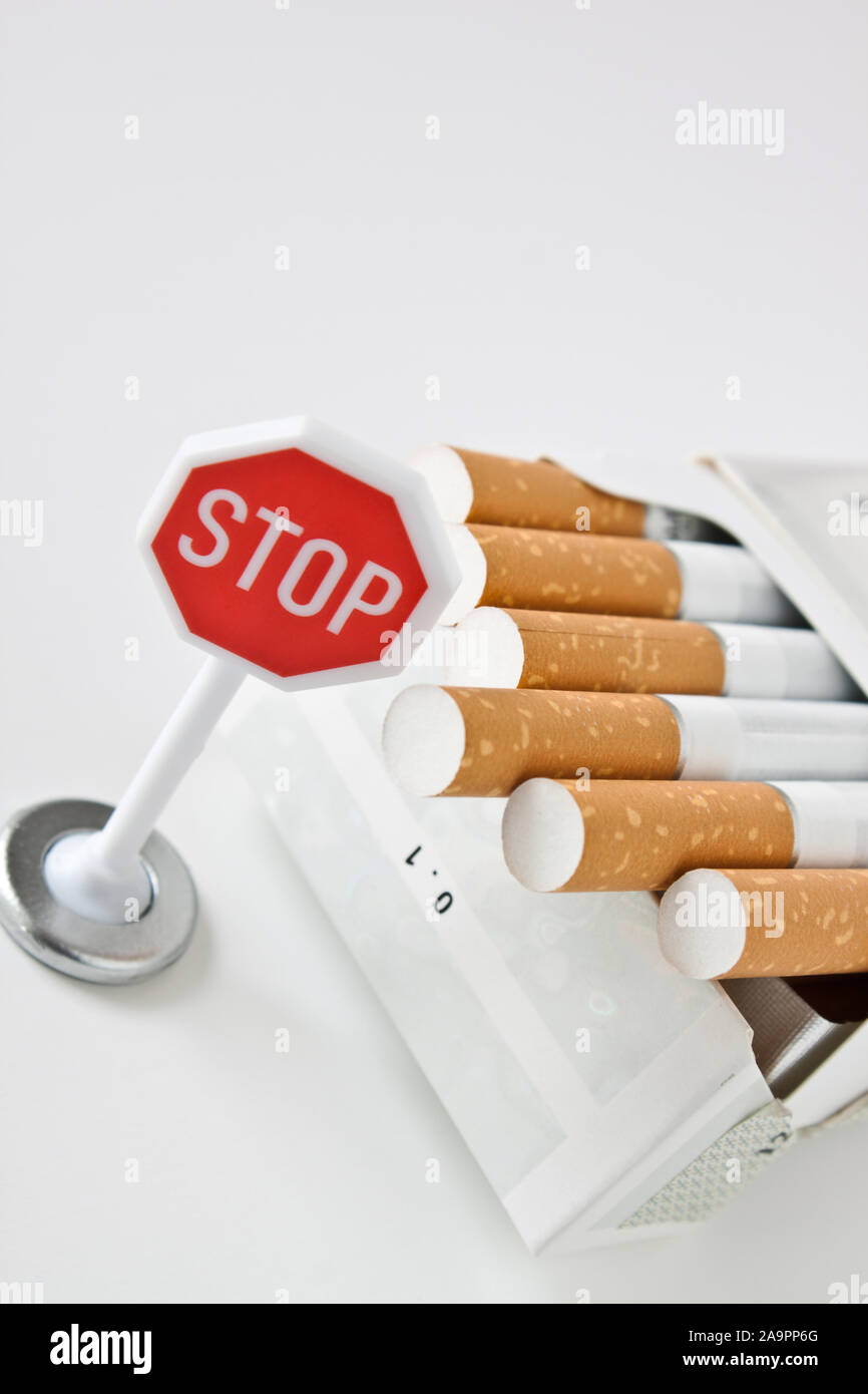 Cigarettes and stop sign on white background close-up Stock Photo - Alamy