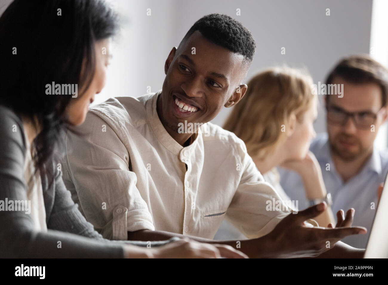 Happy african american young worker discussing project ideas with ...