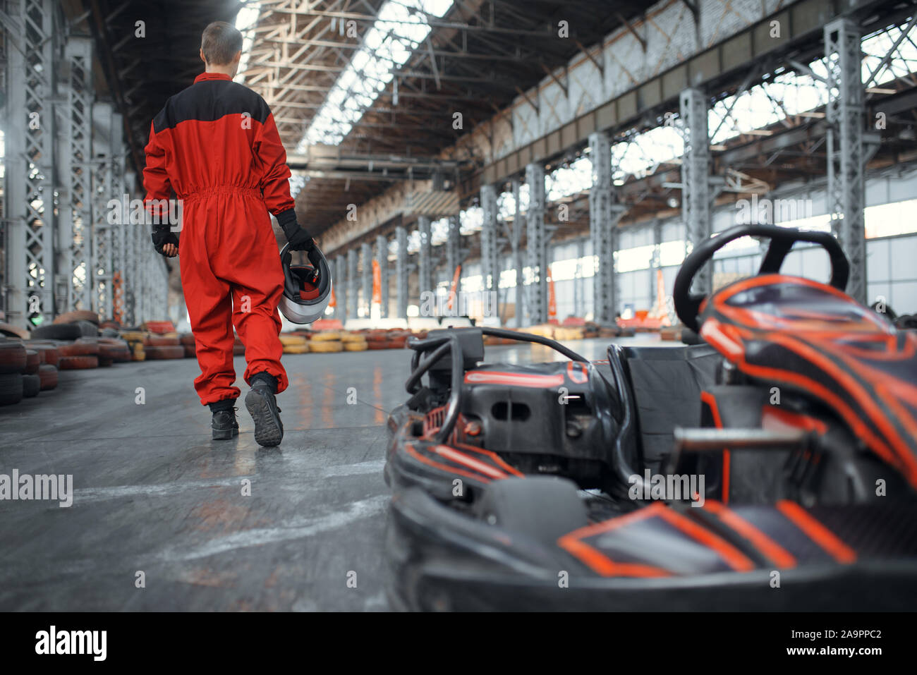 Racer with helmet near go kart car, back view Stock Photo - Alamy
