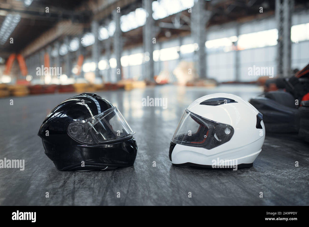 Two go kart helmets on the ground, karting Stock Photo - Alamy