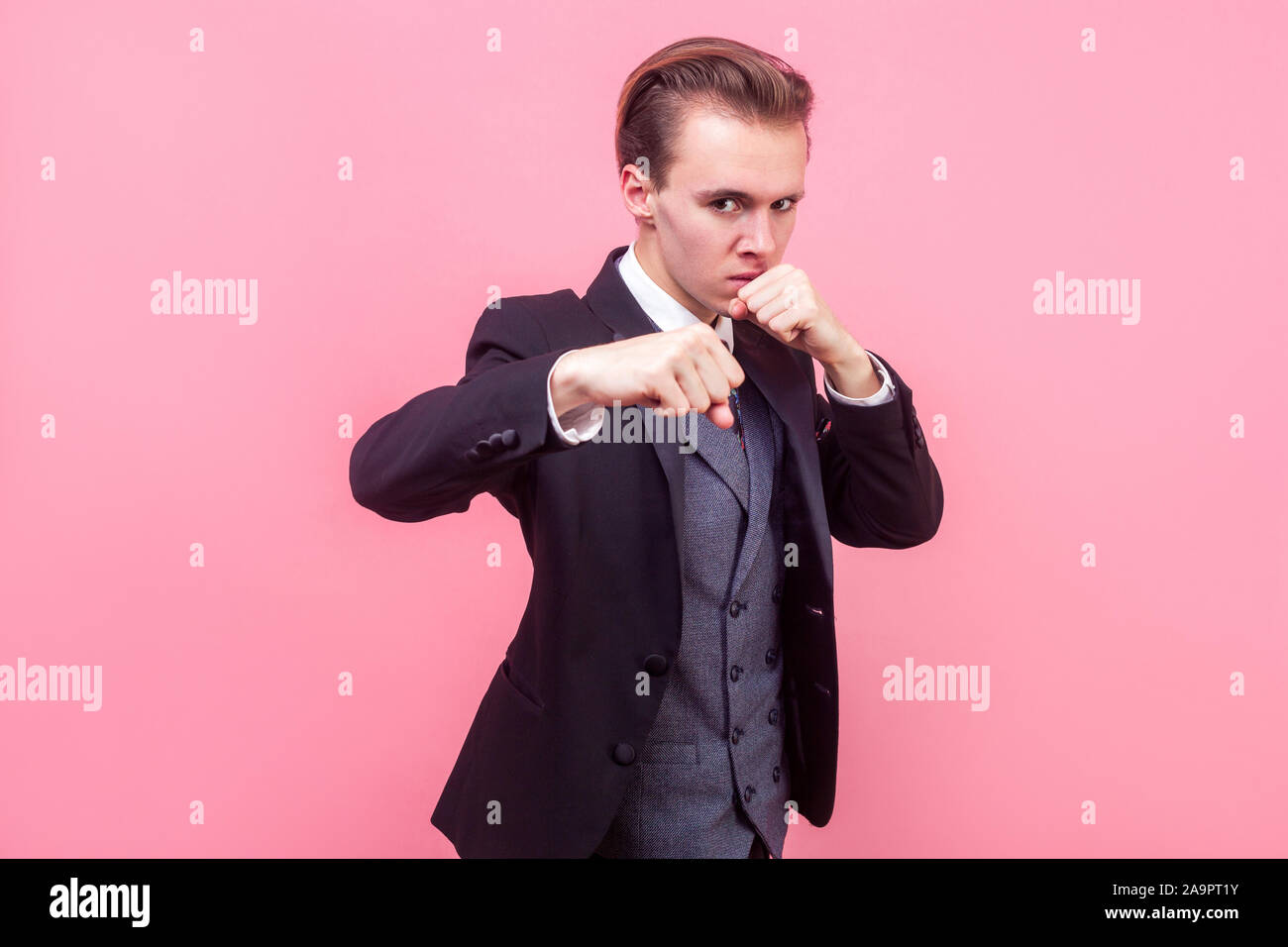 Let's fight! Portrait of aggressive businessman in tuxedo holding fists ...