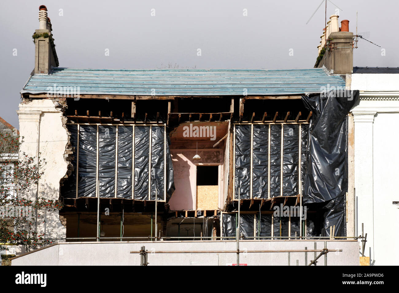 Storm damaged house with a collapsed front showing the rooms inside ...