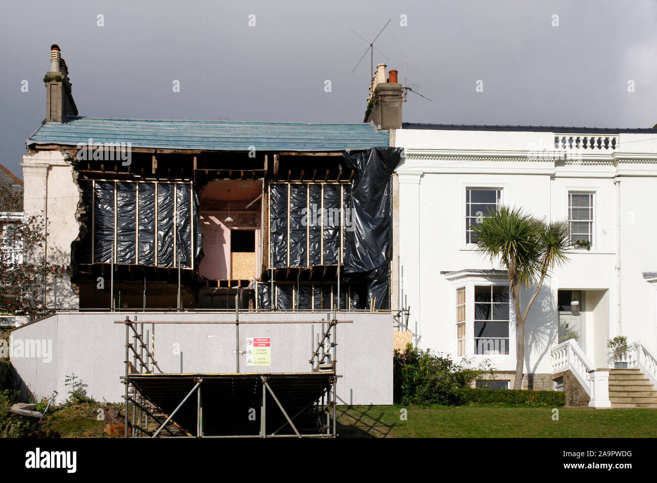 Storm damaged house with a collapsed front showing the rooms inside ...
