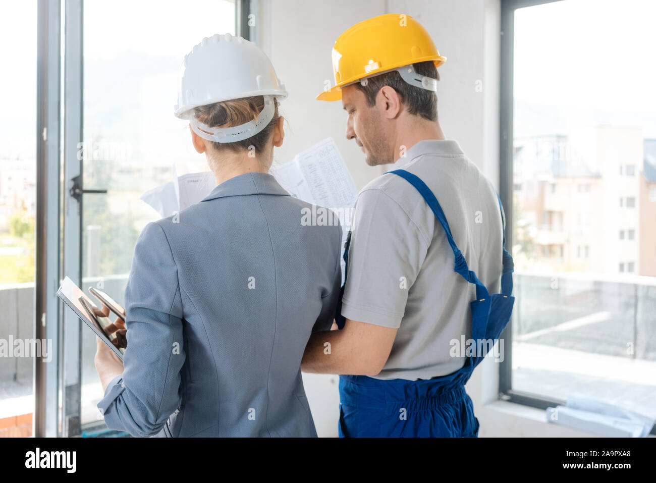 Construction worker and architect looking at plan on site Stock Photo ...
