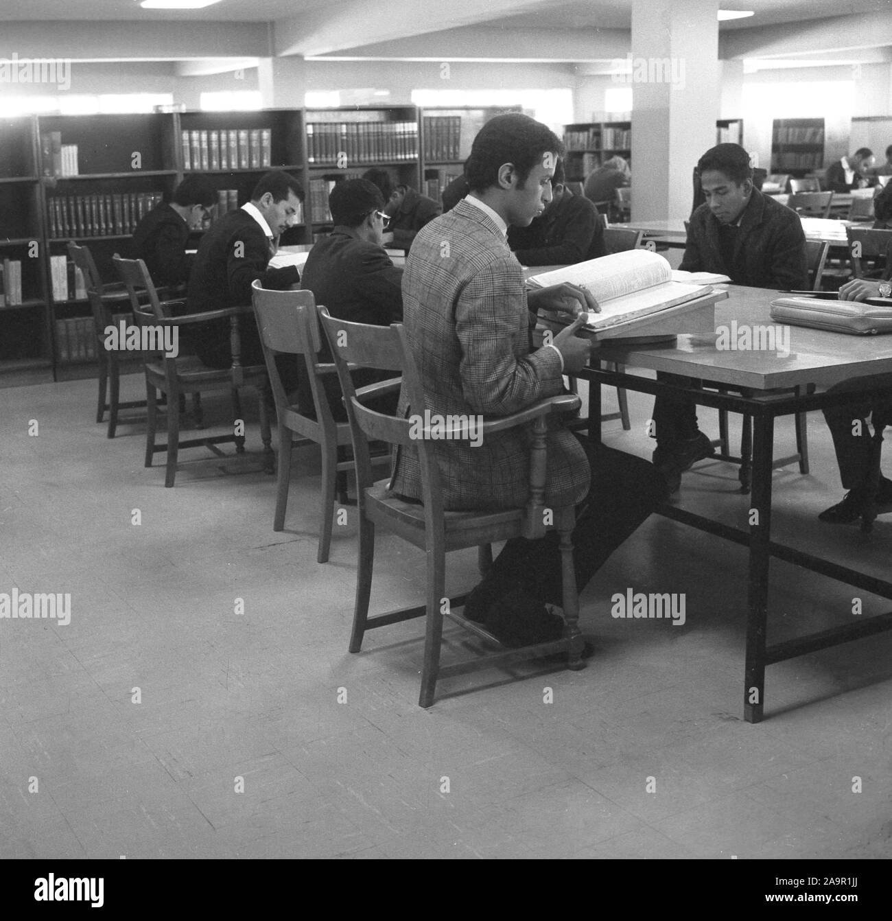 1960s, historical, arab students studying at a table in a library ...
