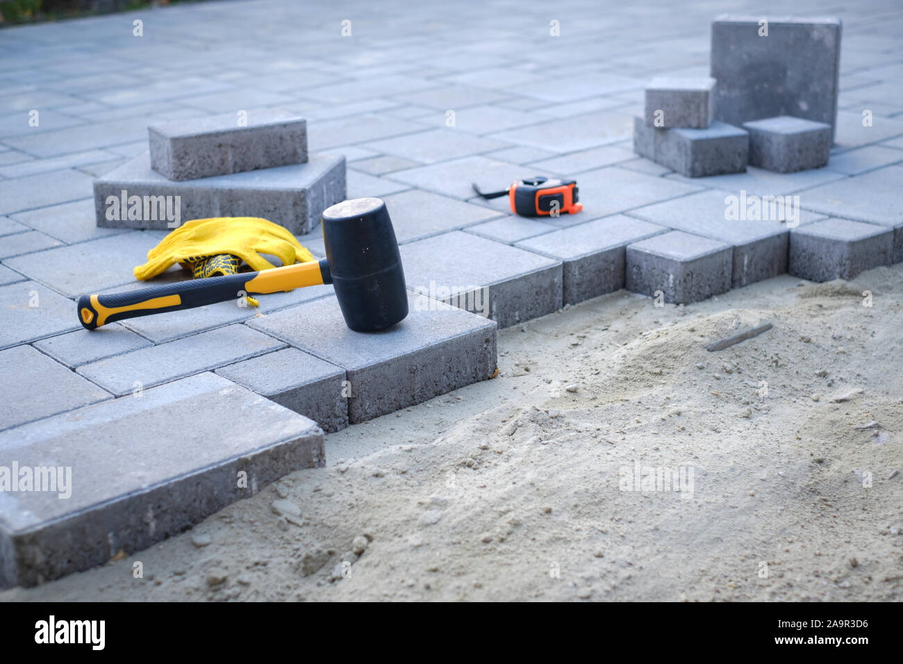 Paving stones pathway paving background. Installing tools on foreground ...