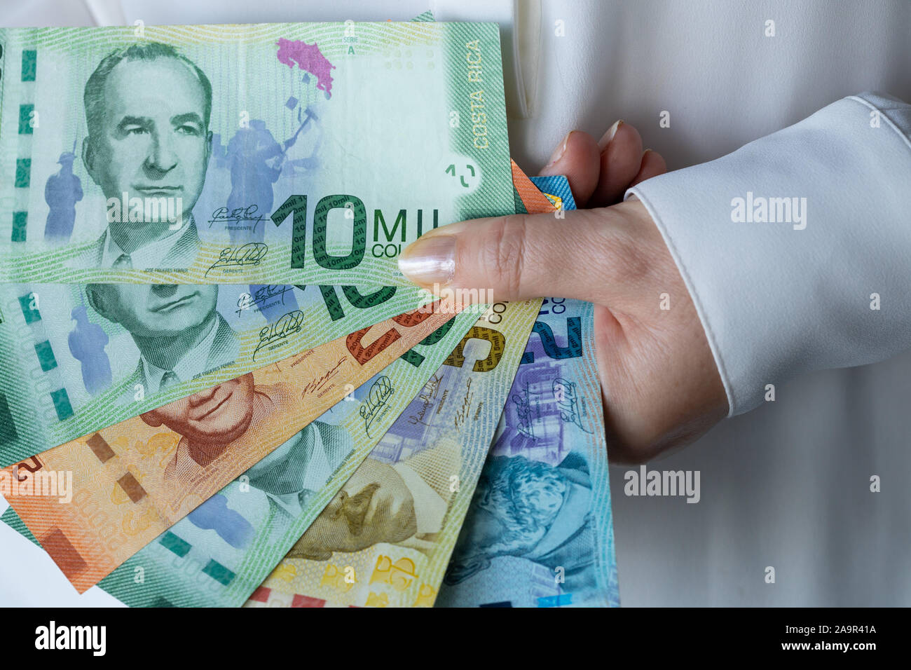 woman holds Costa Rican money, Colones, various banknotes in her hand ...