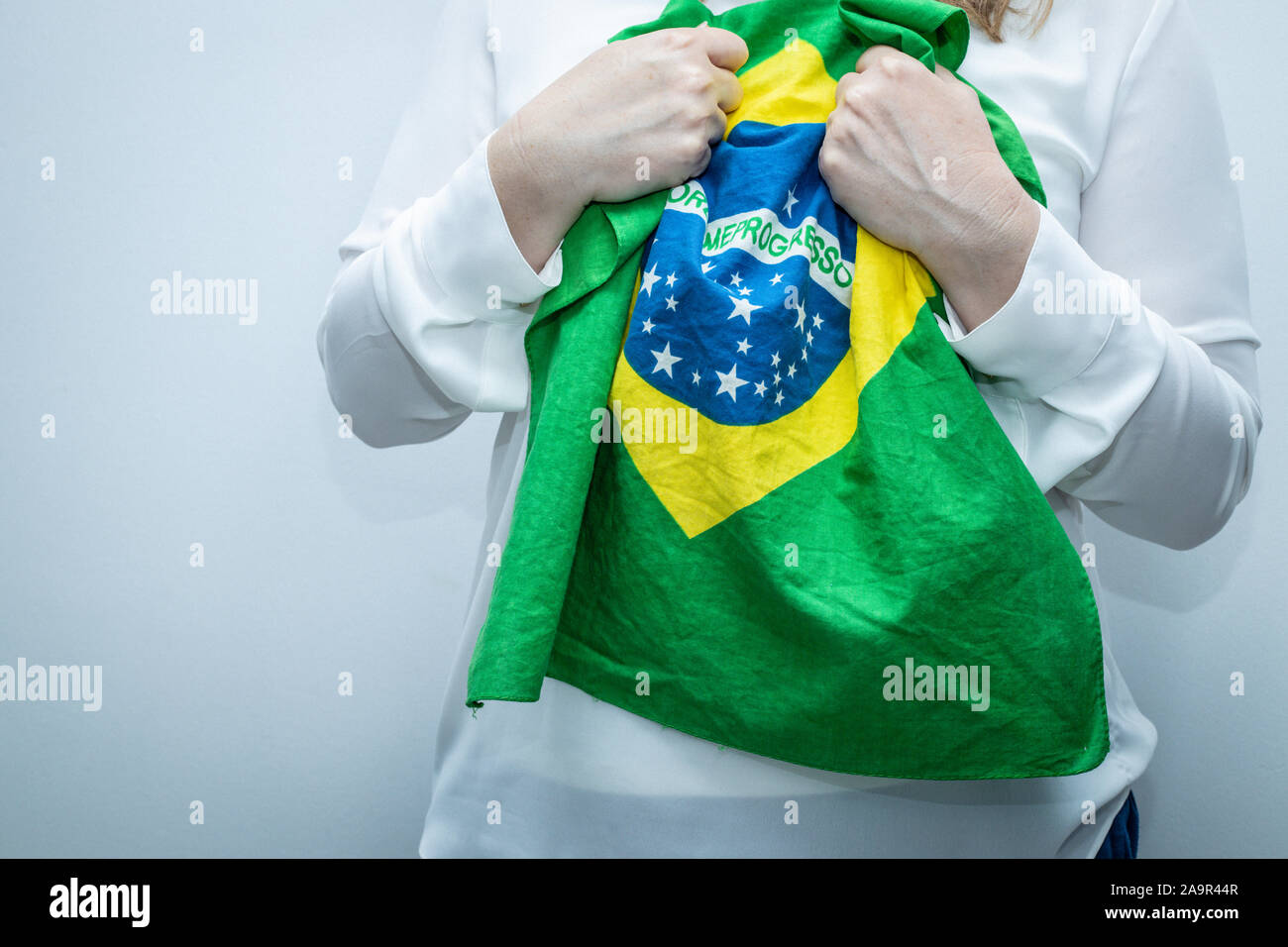 a woman hugs a Brazilian flag to her heart Stock Photo - Alamy