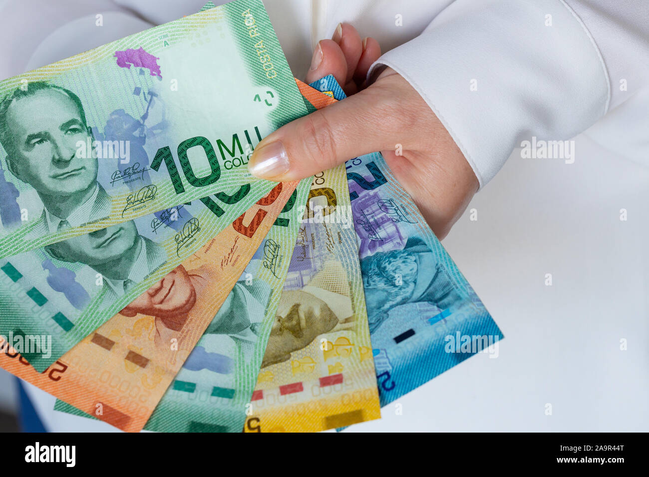 woman holds Costa Rican money, Colones, various banknotes in her hand ...