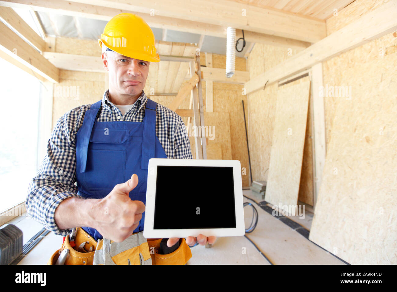 Construction worker holding digital tablet standing at construction ...