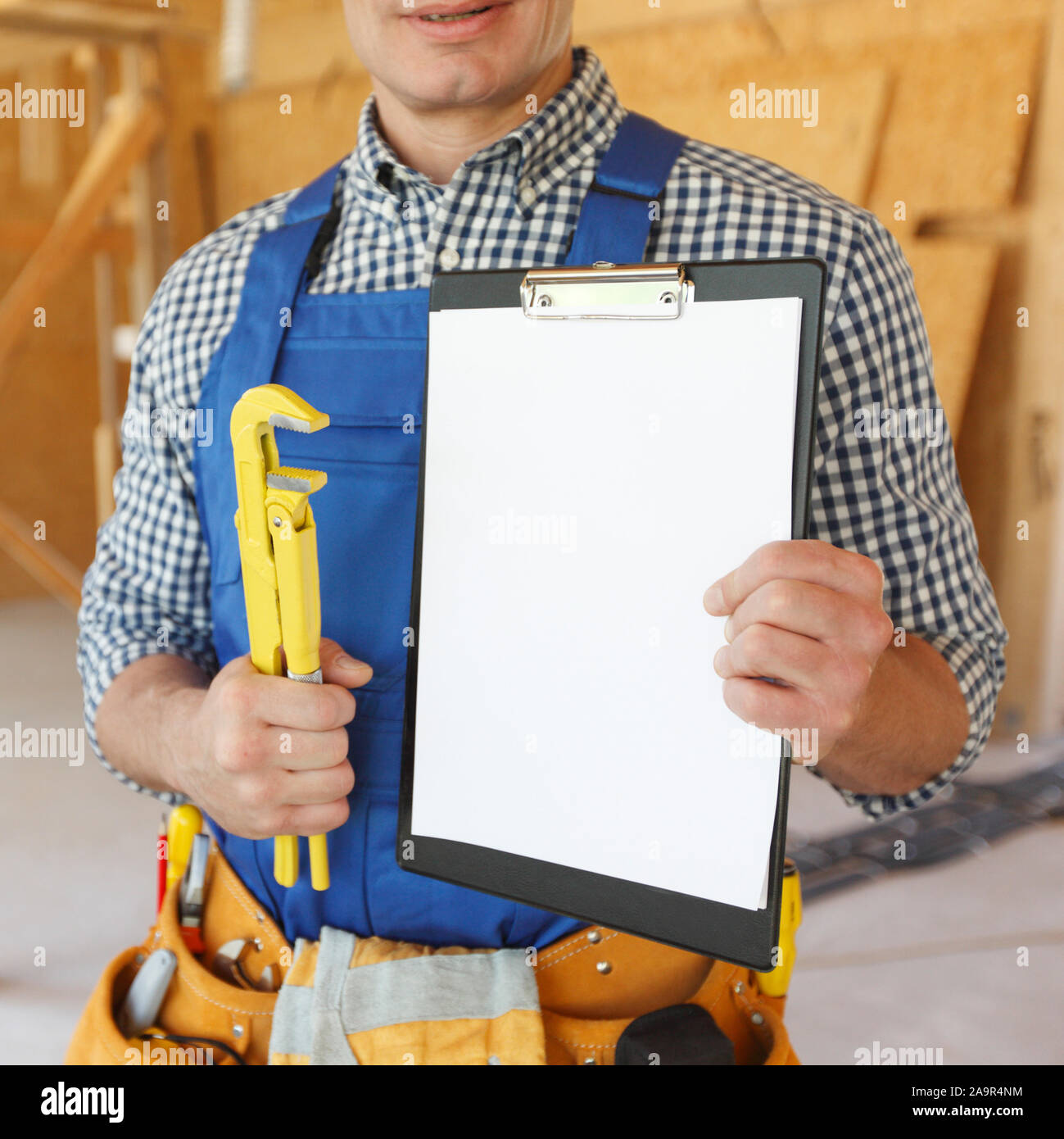 Workman with adjustable wrench and folder with blank document at ...