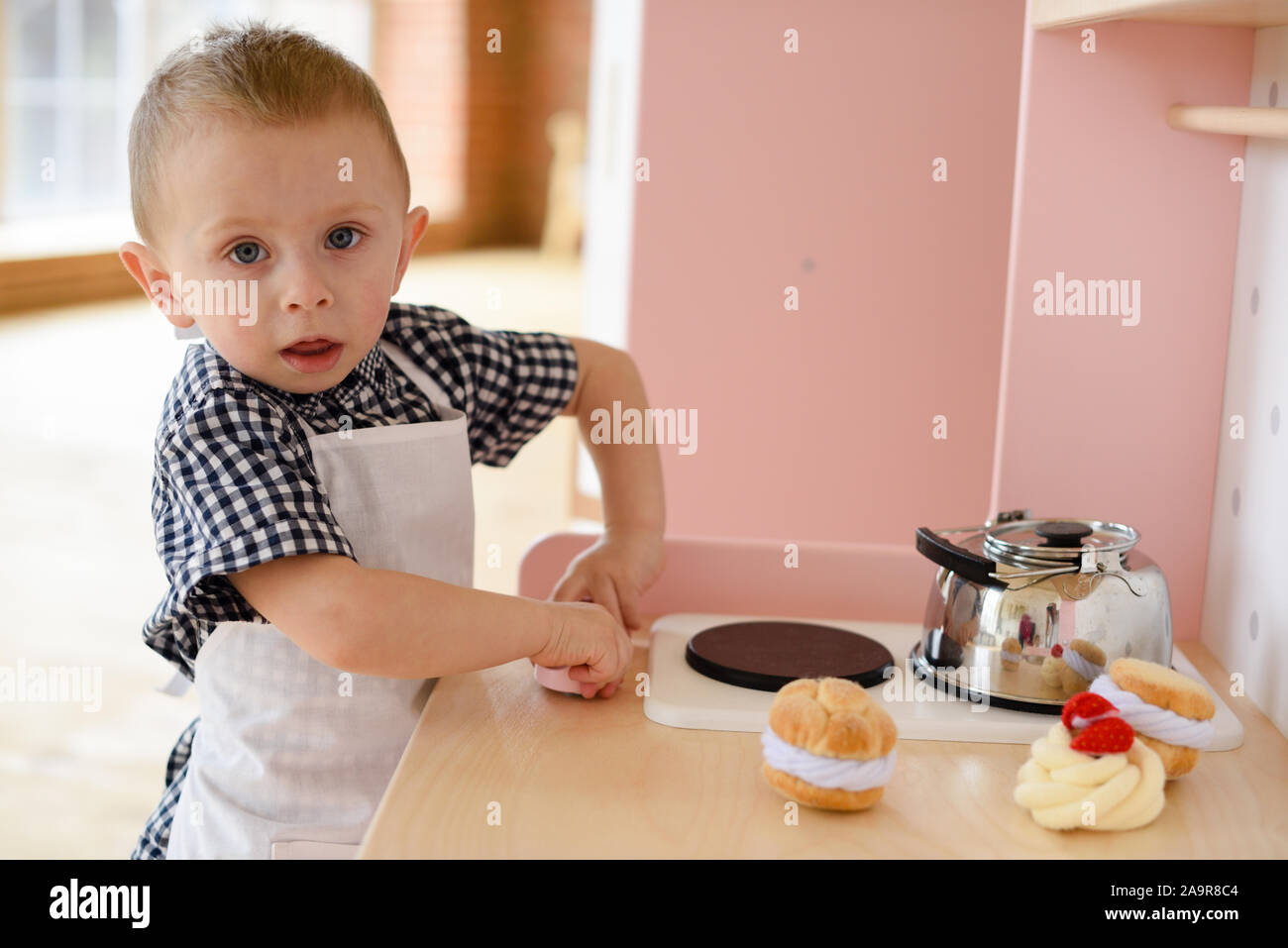 Child playing chef concept. Serious little boy in apron playing with ...