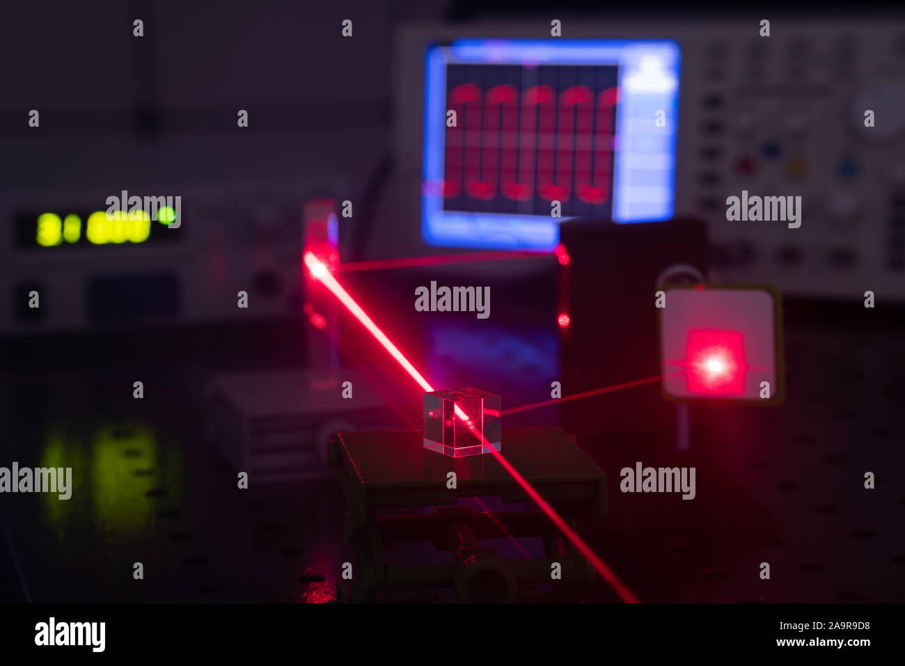 Experiment in optic lab with laser device. Red laser on optical table ...