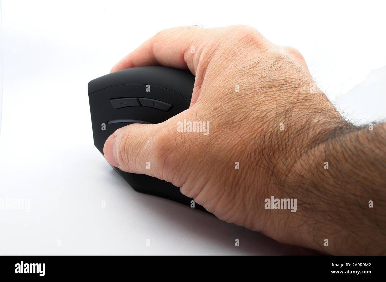 Male right hand holding an ergonomic black mouse on white background ...