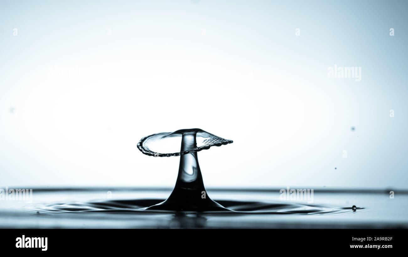 Close-up of a water drop falling on water surface Stock Photo - Alamy